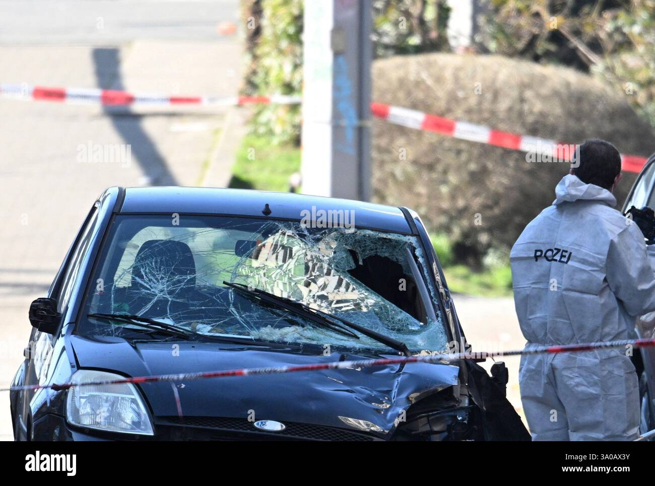 Forensics officers examine a damaged vehicle on an access road to the ...