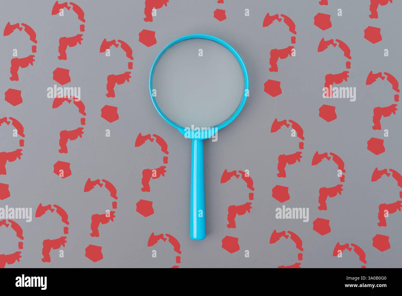 A magnifying glass on a gray surface with scattered red question mark ...