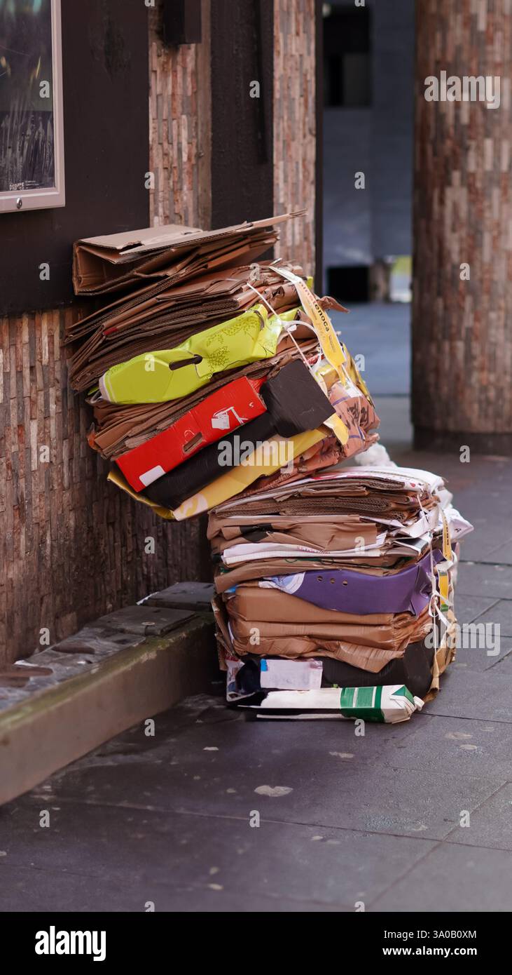 Folded cardboard neatly stacked outside, prepared for waste recycling ...