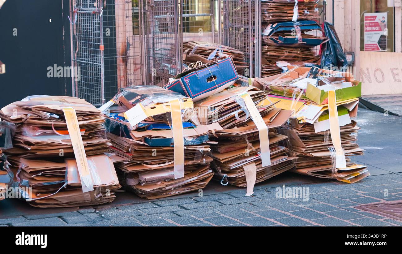 Large stacks of used cardboard outside, organized for waste recycling ...