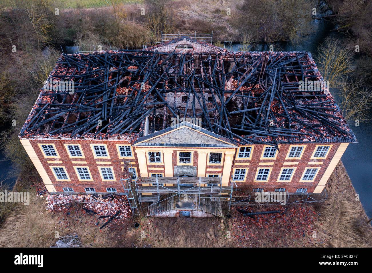 Dassow, Germany. 03rd Mar, 2025. Charred roof beams lie on the remains ...
