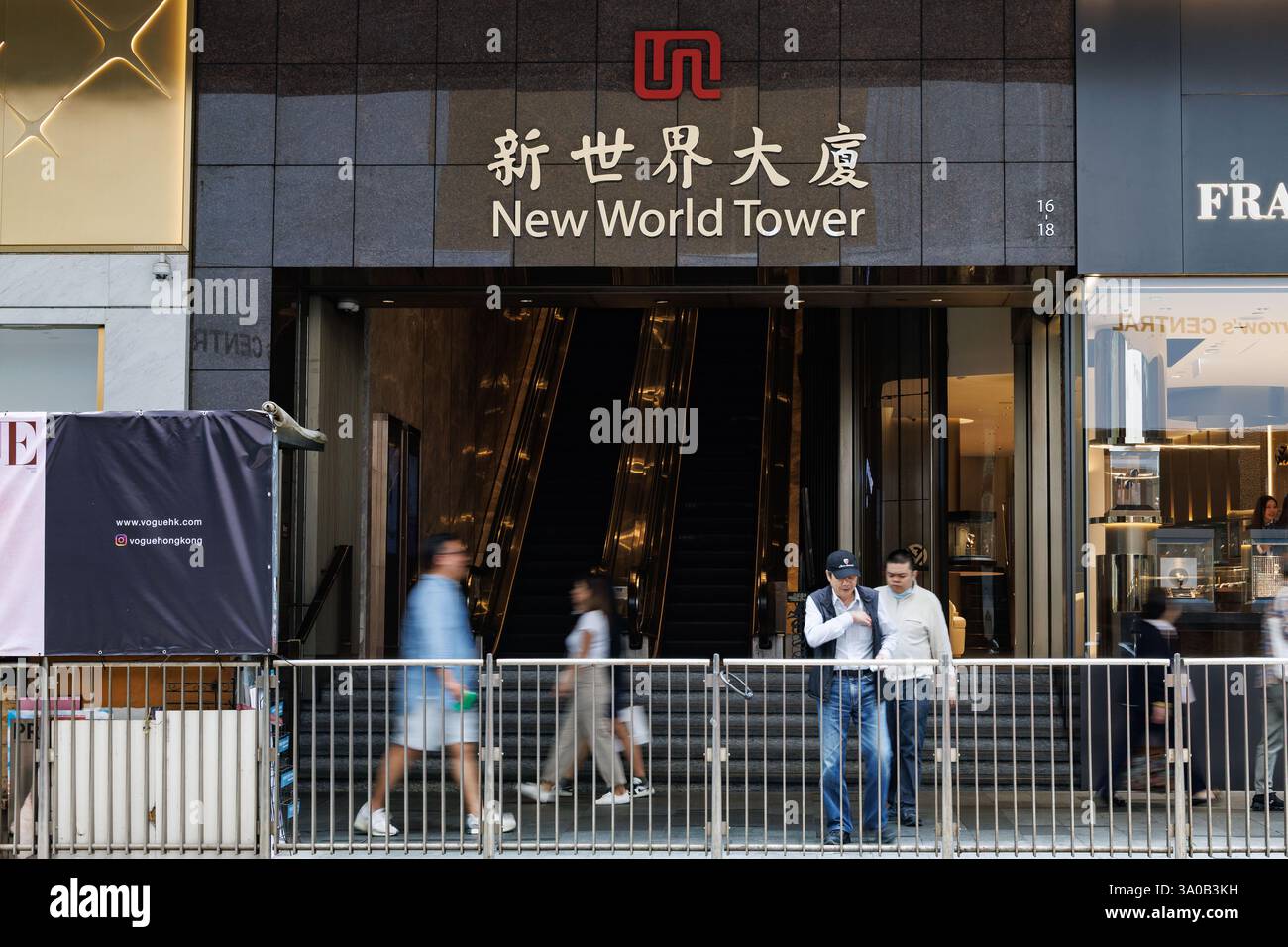People walk past the headquarters of New World Development at New World ...