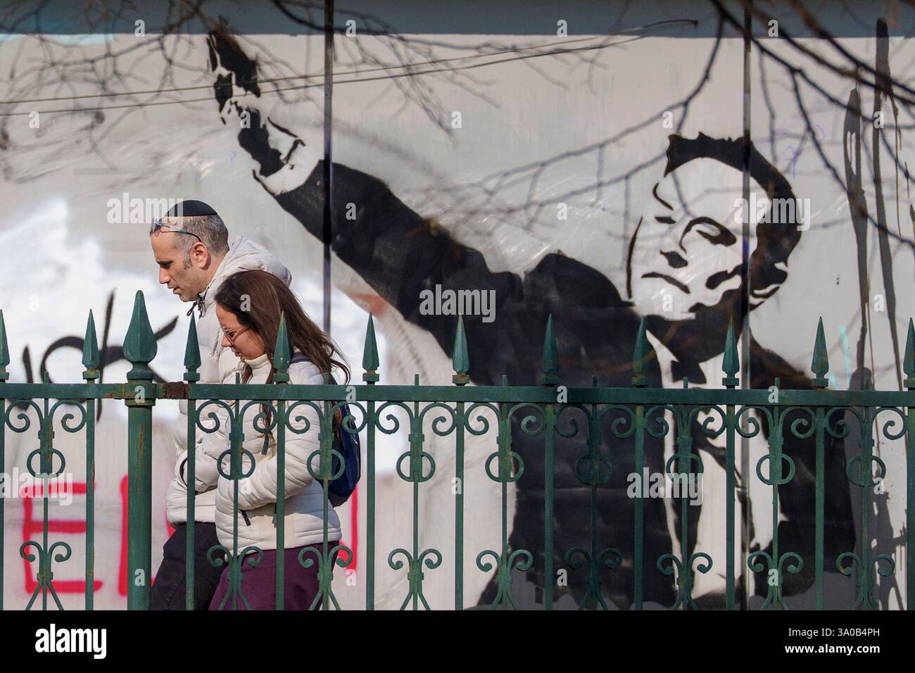 People walk by graffiti depicting Elon Musk, in Bucharest, Romania ...