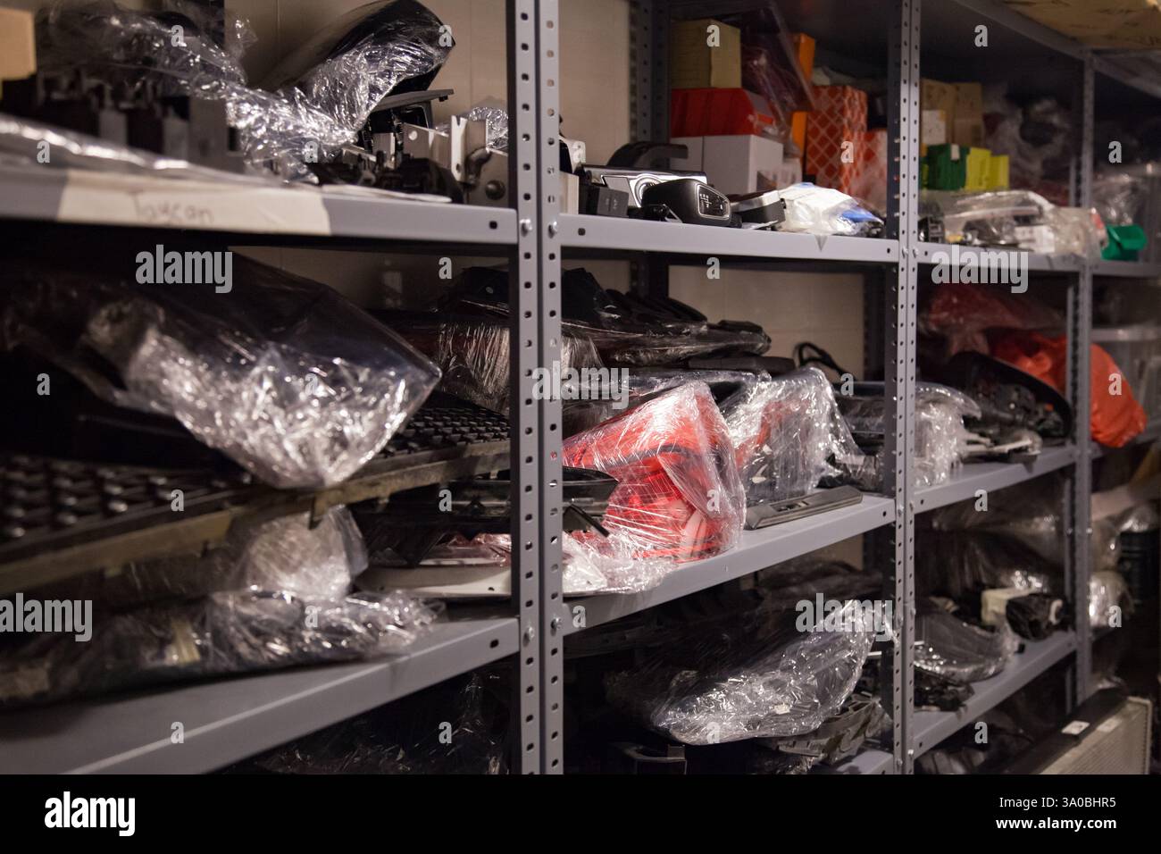 Metal shelves with various car parts from new modern vehicles in an ...