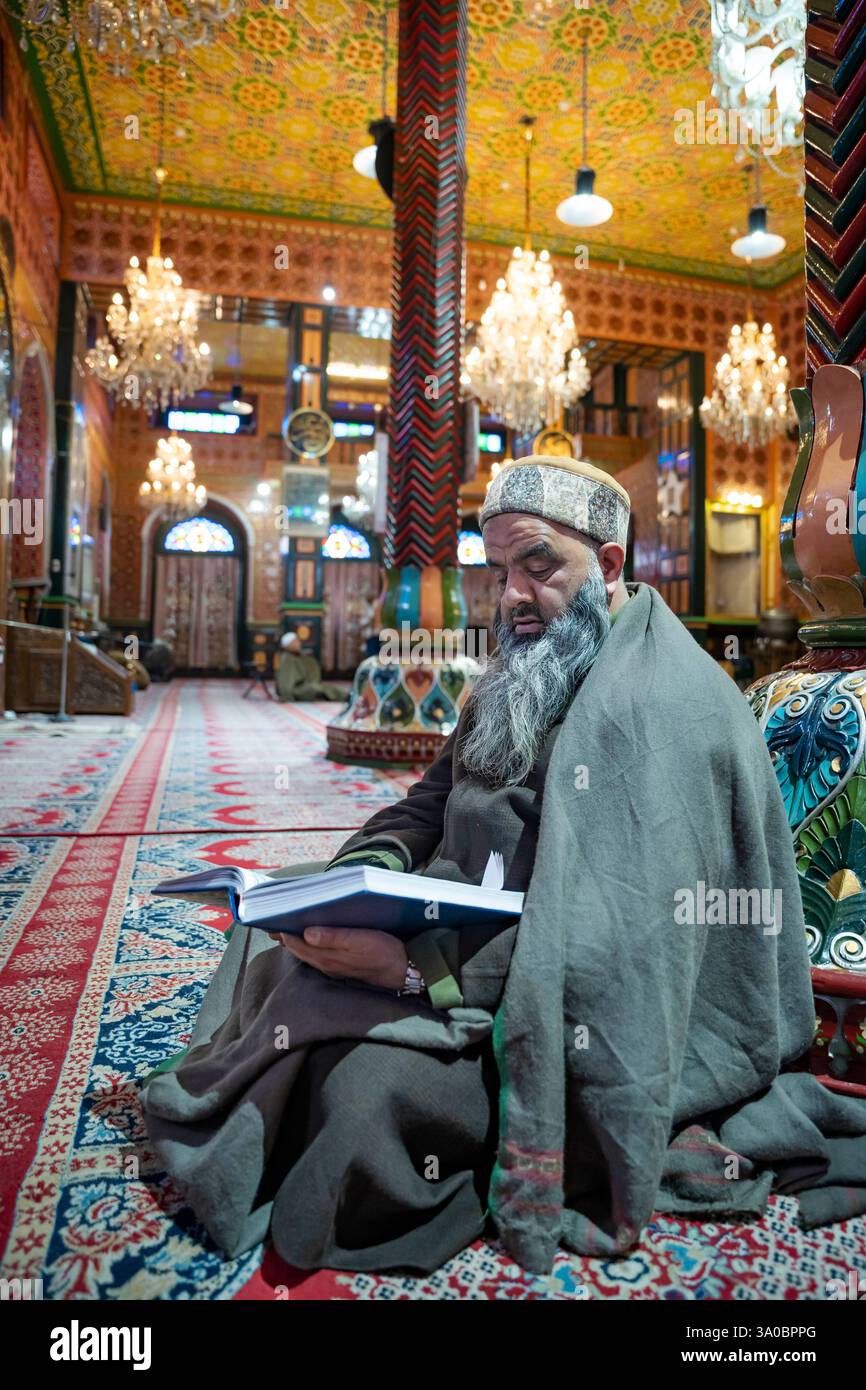 A Kashmiri Muslim man recites from the Islamic book Quran inside a ...
