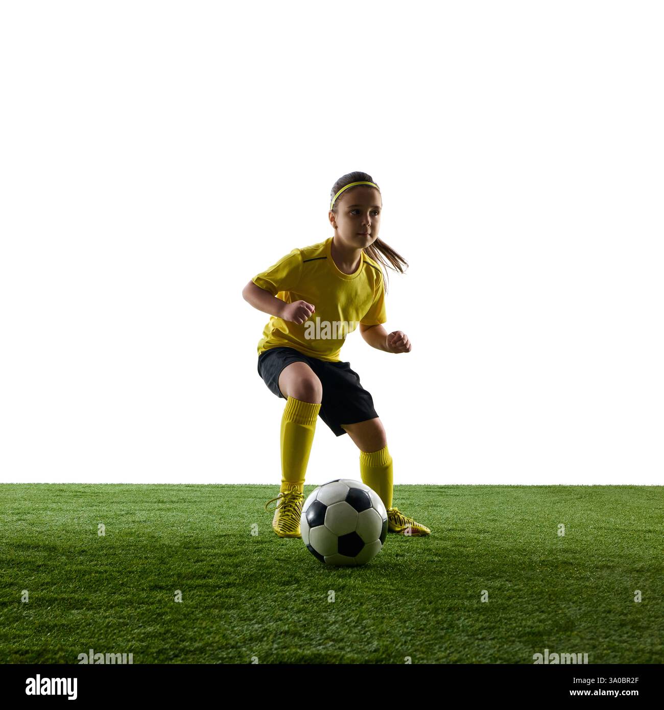 Focused girl in sportswear dribbling soccer ball, moving forward on ...