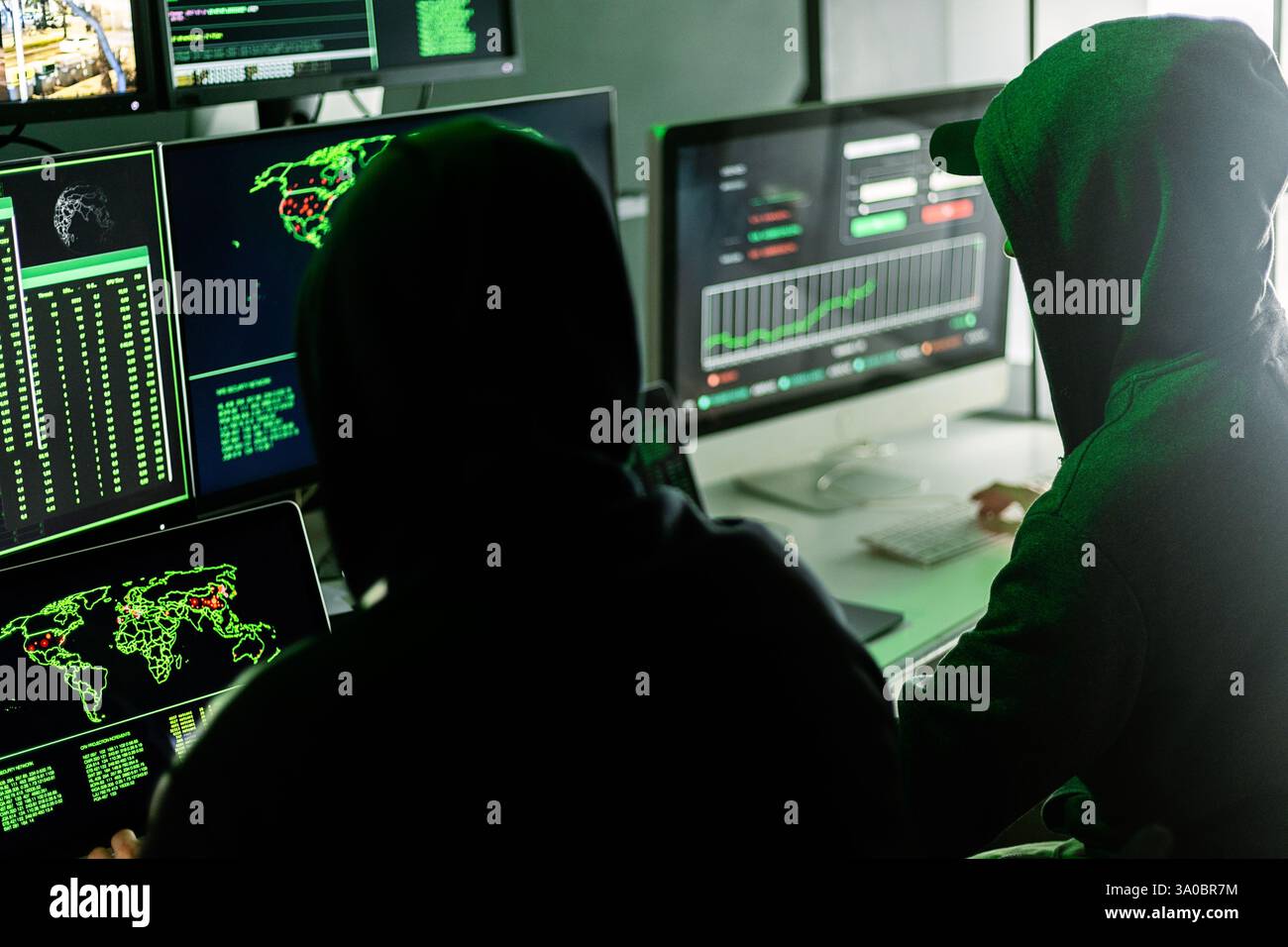 Hackers working on computers showing world maps and security camera ...