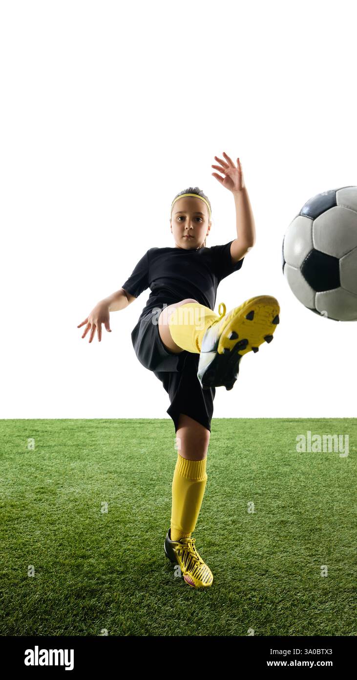 Front view of focused girl in black uniform and yellow socks in motion ...