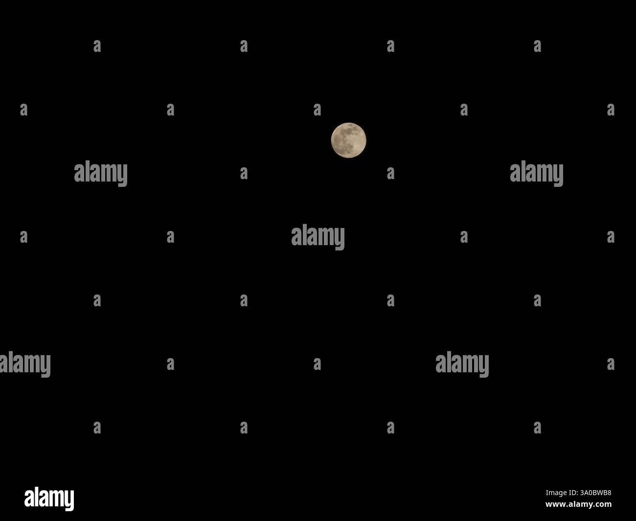 A full moon in the center, in a completely dark sky. Its illuminated ...