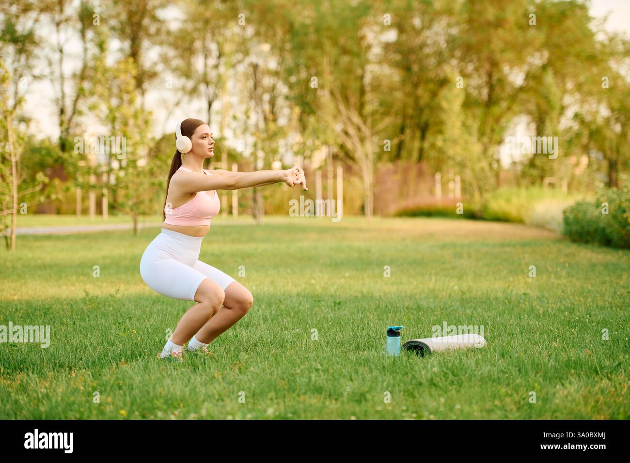 Sporty woman exercises with determination, performing squats on a ...