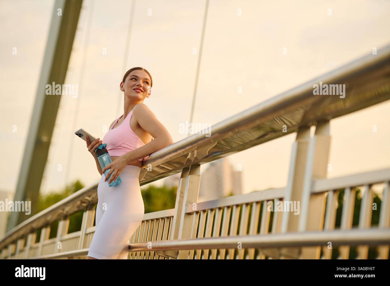 Athletic young woman with a radiant smile takes a break during her ...