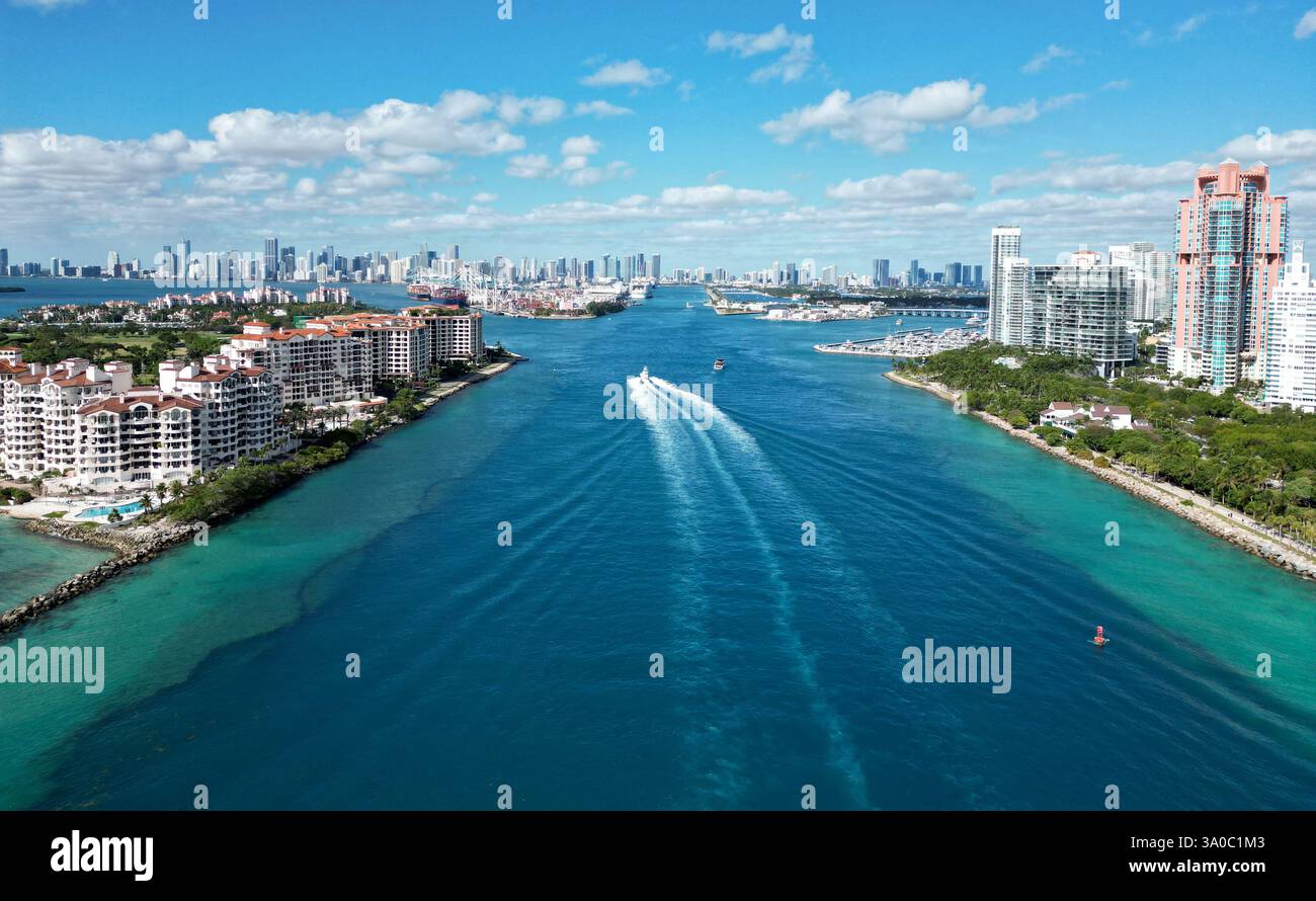 Miami south beach with motorboat passing canal between Fisher island ...