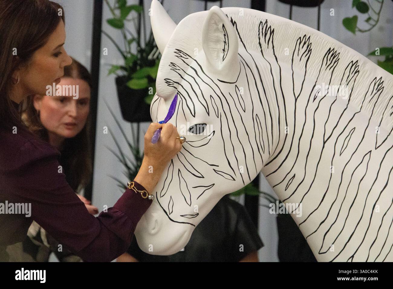 H.M. The Queen Mary of Denmark paints a zebra together with children who all suffer from rare ...