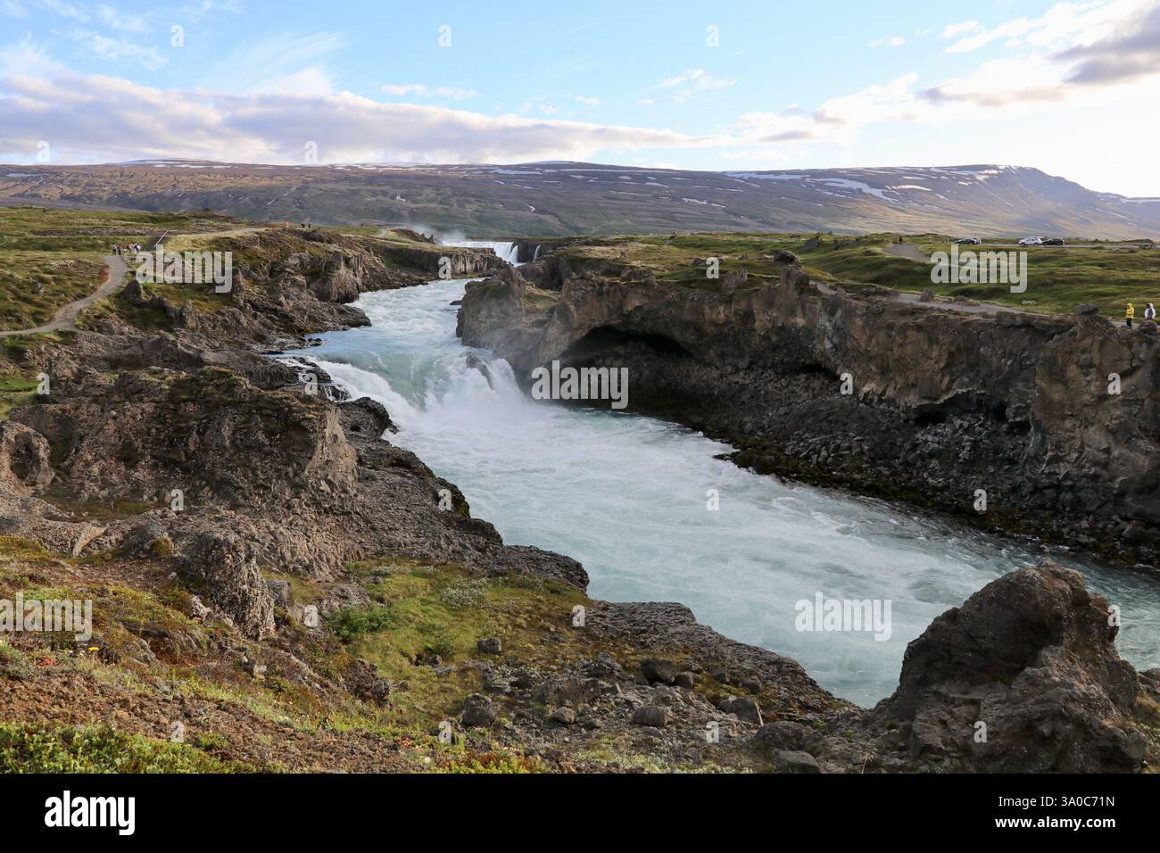 Icelandic landscape with volcanic rocks and the rapid flowing water of ...