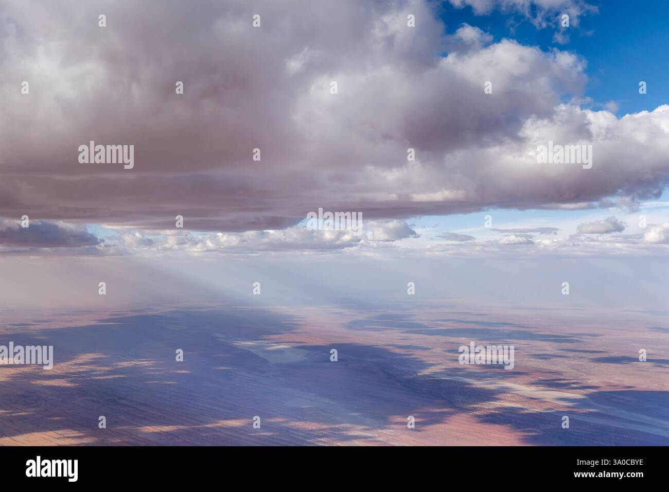 aerial landscape with large thunderstorm clouds casting shadows over ...