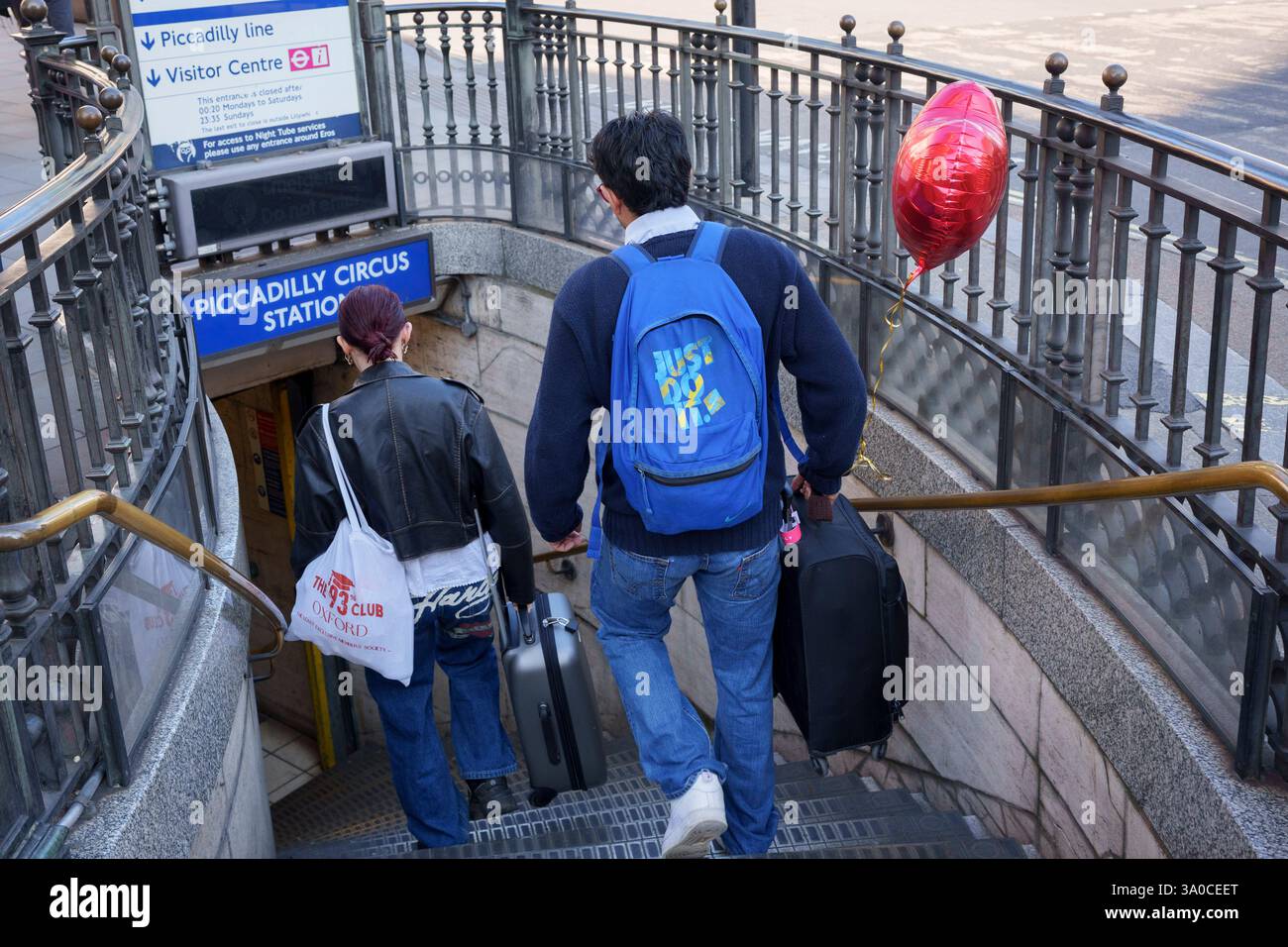 A couple with a helium heart balloon descend the steps to Piccadilly ...
