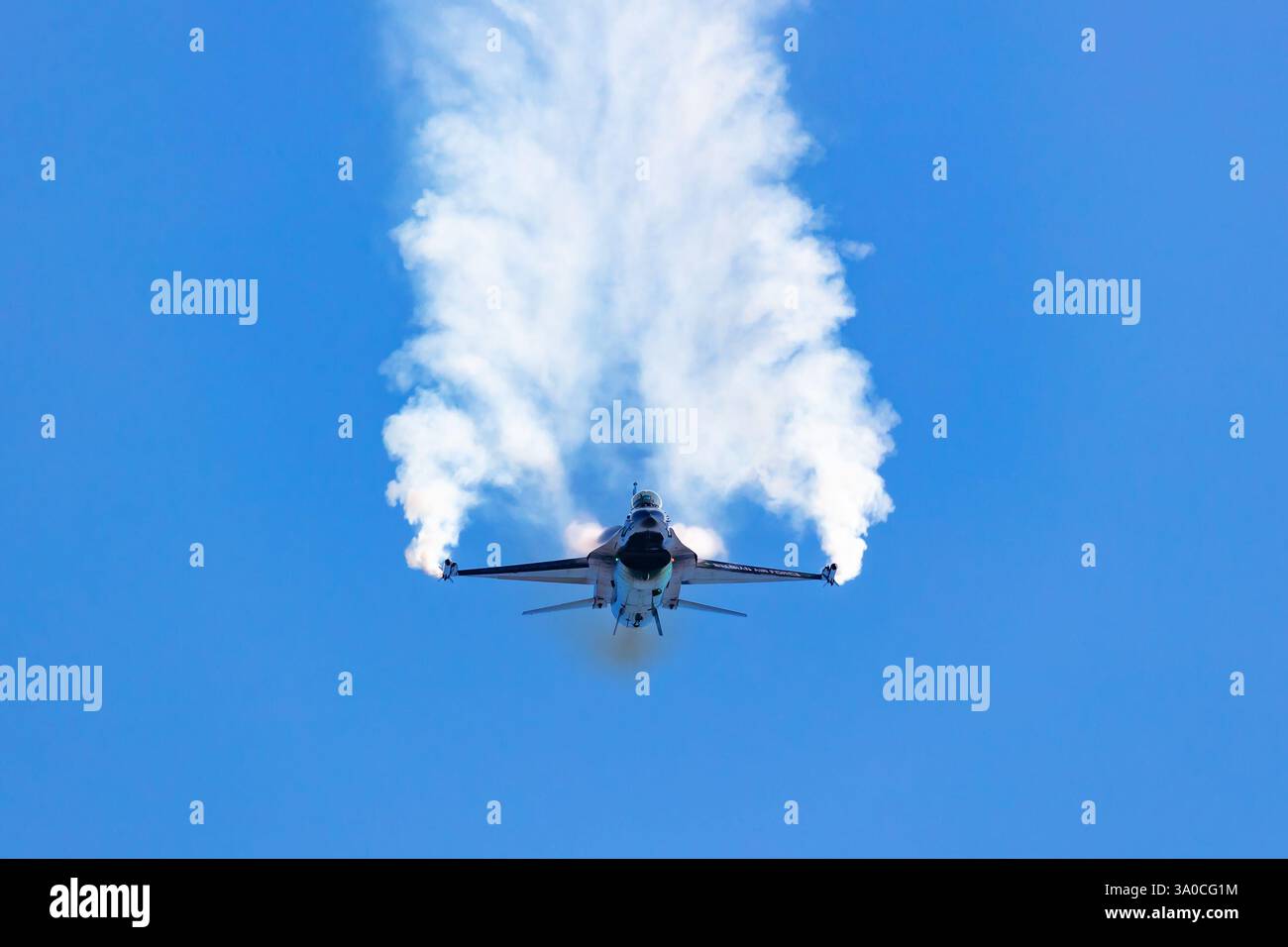 A fighter jet performing a high-altitude maneuver against clear blue ...