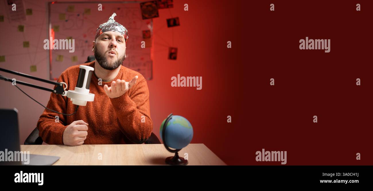 Bearded man in aluminum foil hat sending air kiss while Live streaming ...