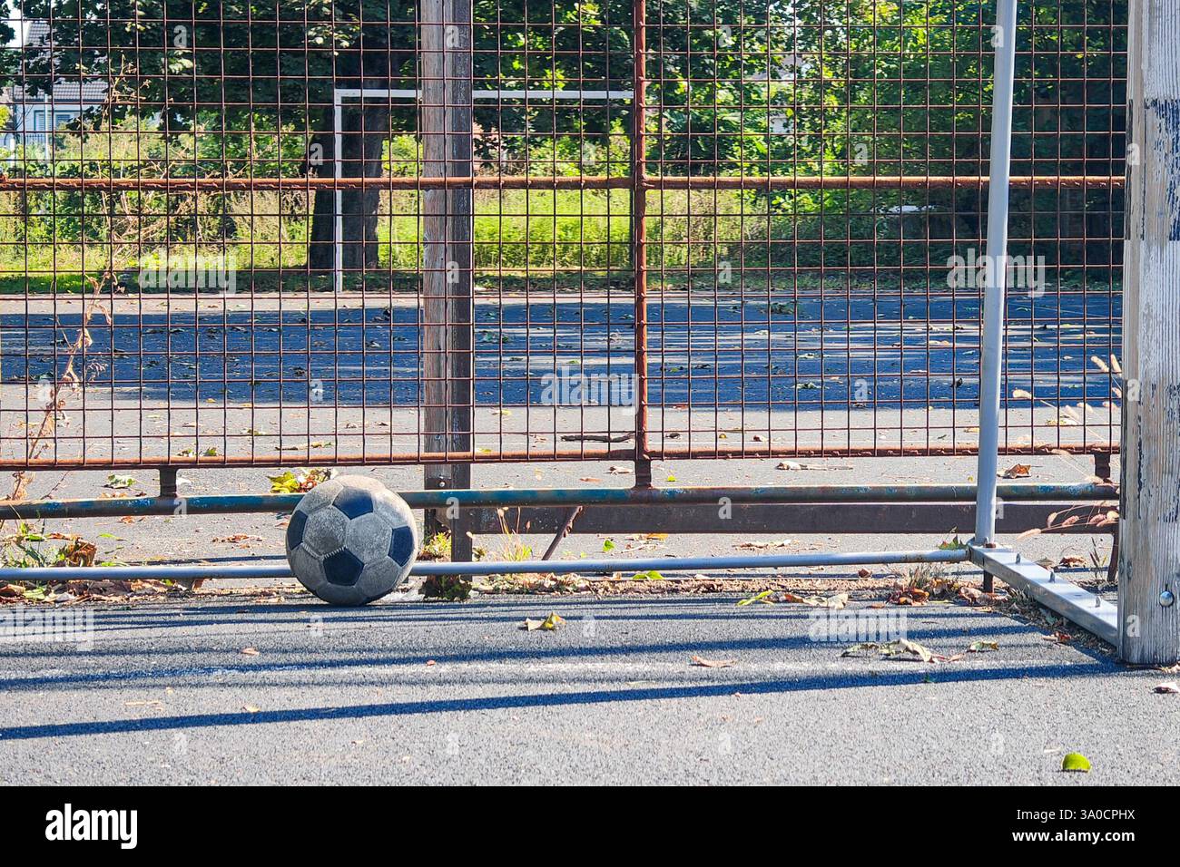 Worn out soccer ball on abandoned sports field with rusty fence Stock ...