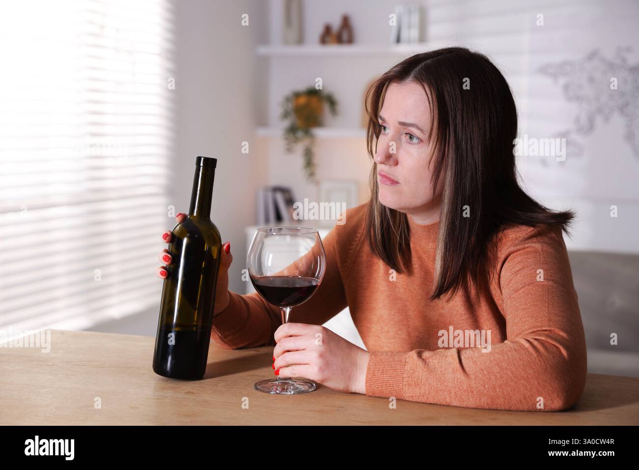 Alcohol addiction. Miserable woman with wine at table indoors Stock ...