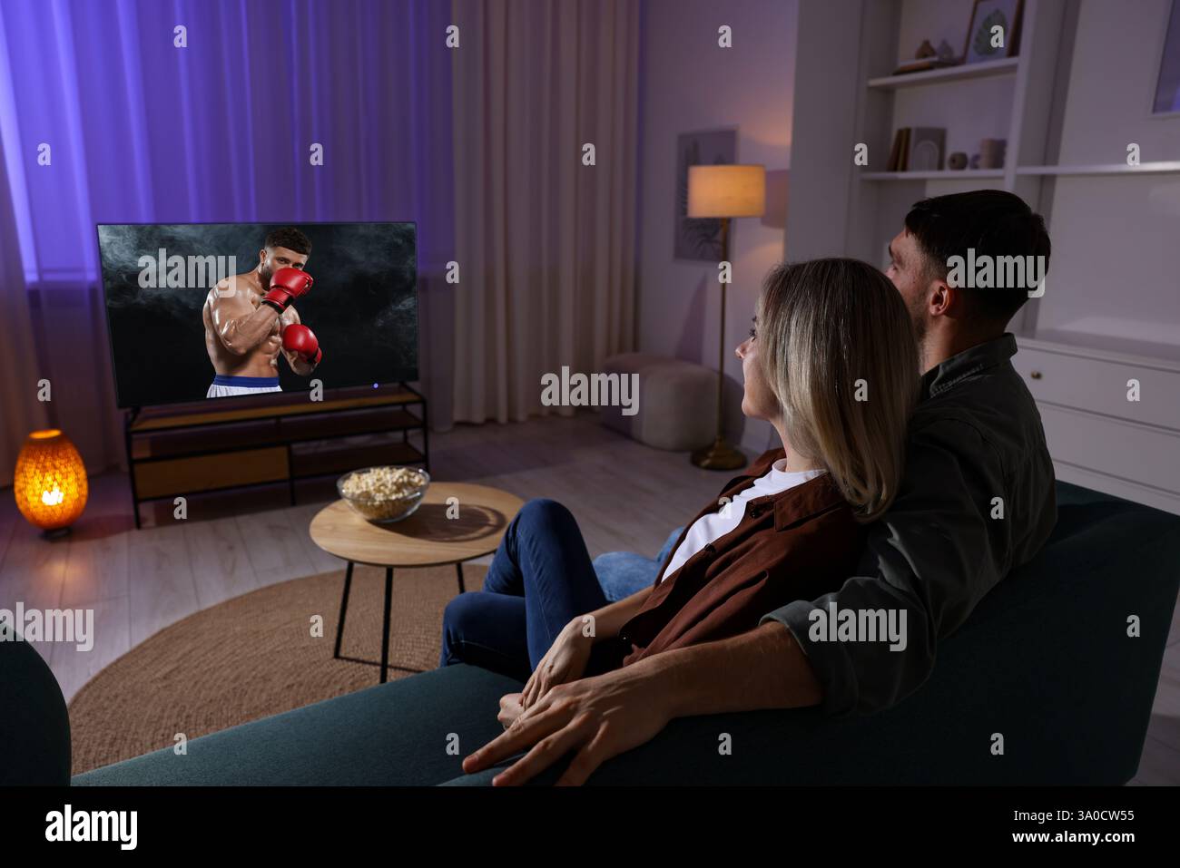 Couple watching boxing fight on TV set at home Stock Photo - Alamy