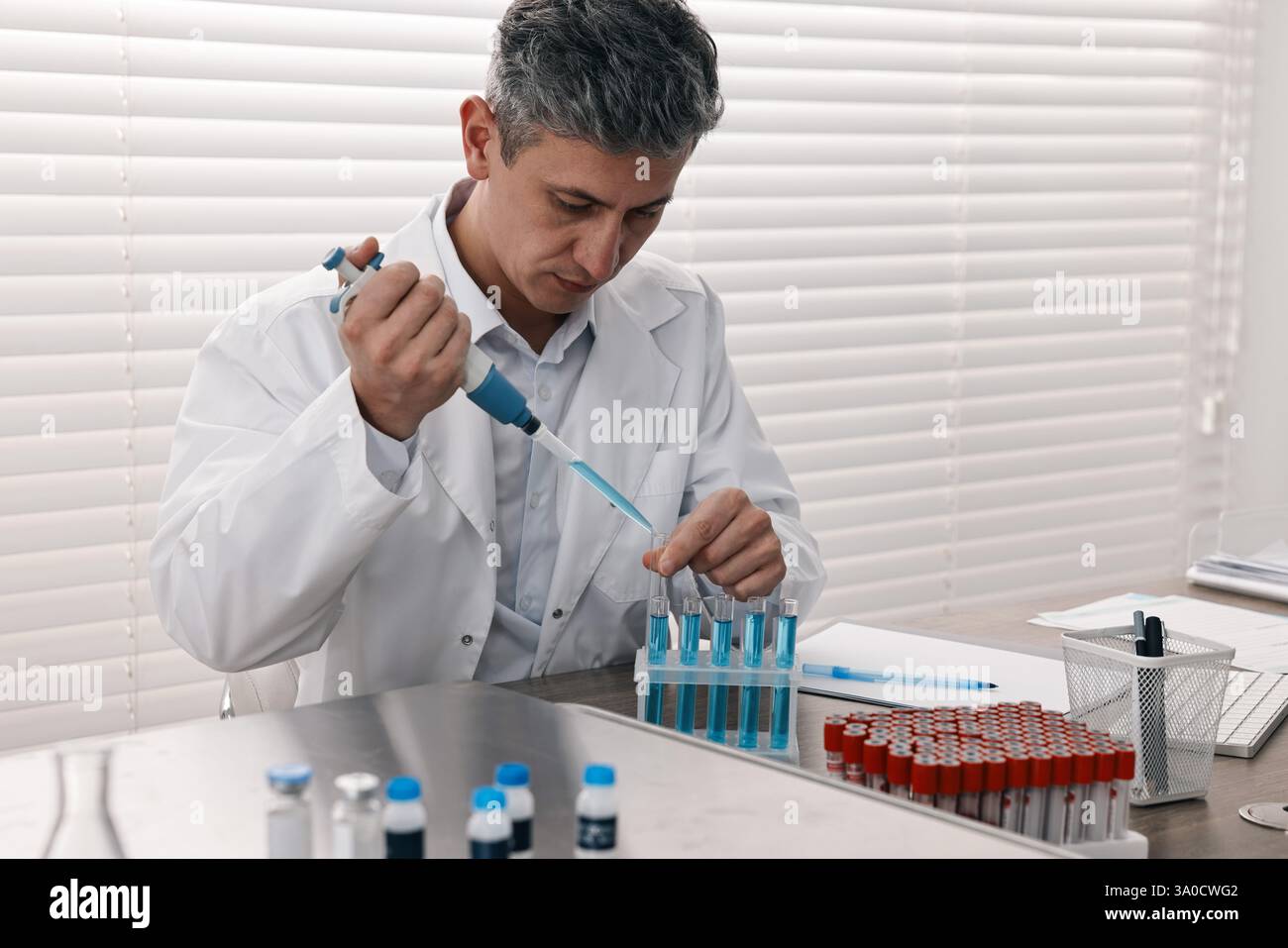 Scientist with micropipette and test tubes working in laboratory Stock ...