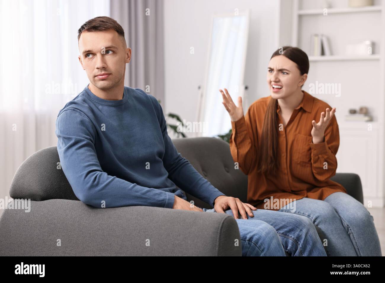 Husband ignoring his emotional wife at home Stock Photo - Alamy