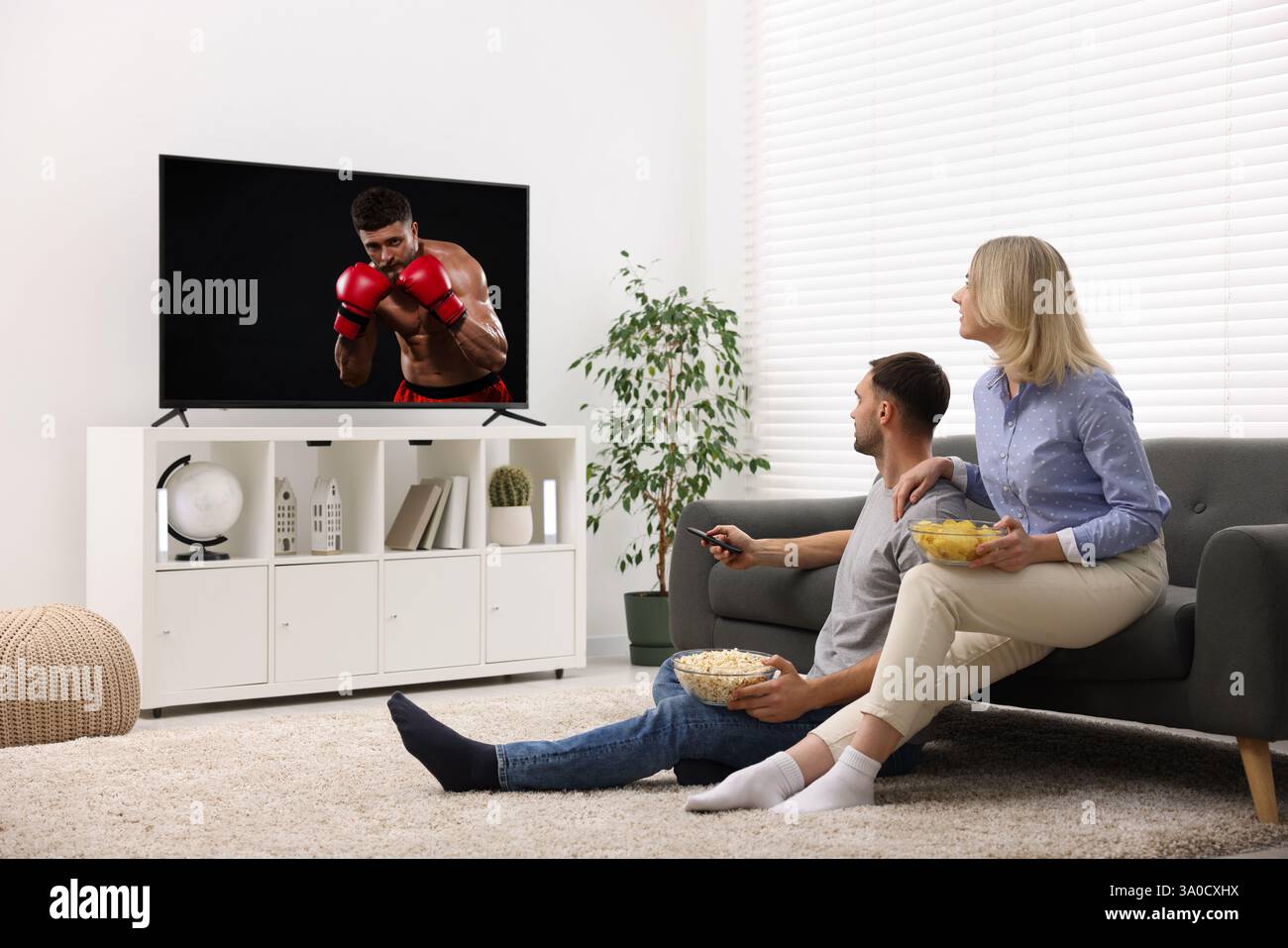 Couple watching boxing fight on TV set at home Stock Photo - Alamy