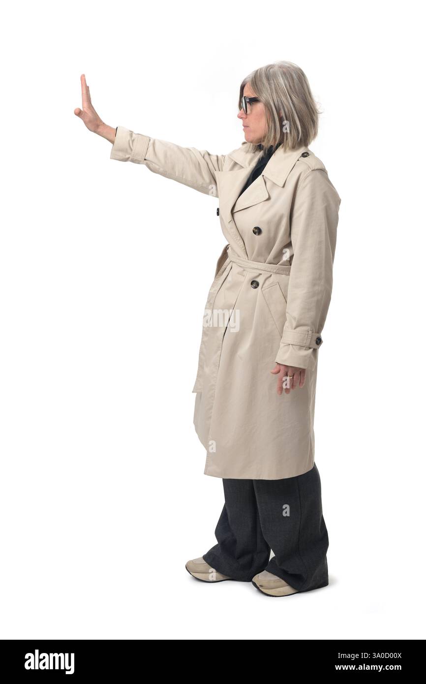 side view of a woman standing with arm raised showing stop sign on ...