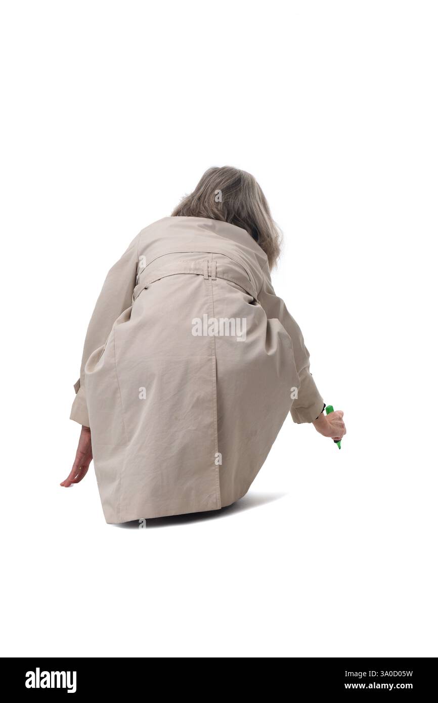 back view of a woman squatting who is drawing with a marker on the ...
