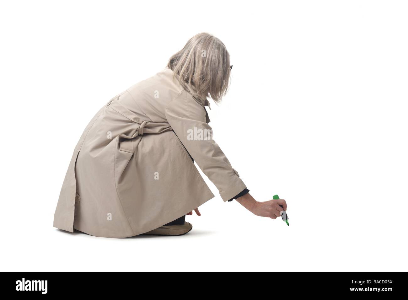 side view of a woman squatting who is drawing with a marker on the ...