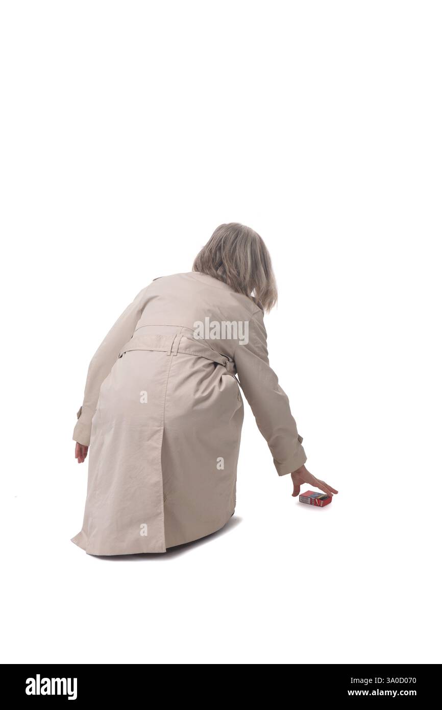 back view of a woman picking up a cigarette pack on the floor on white ...