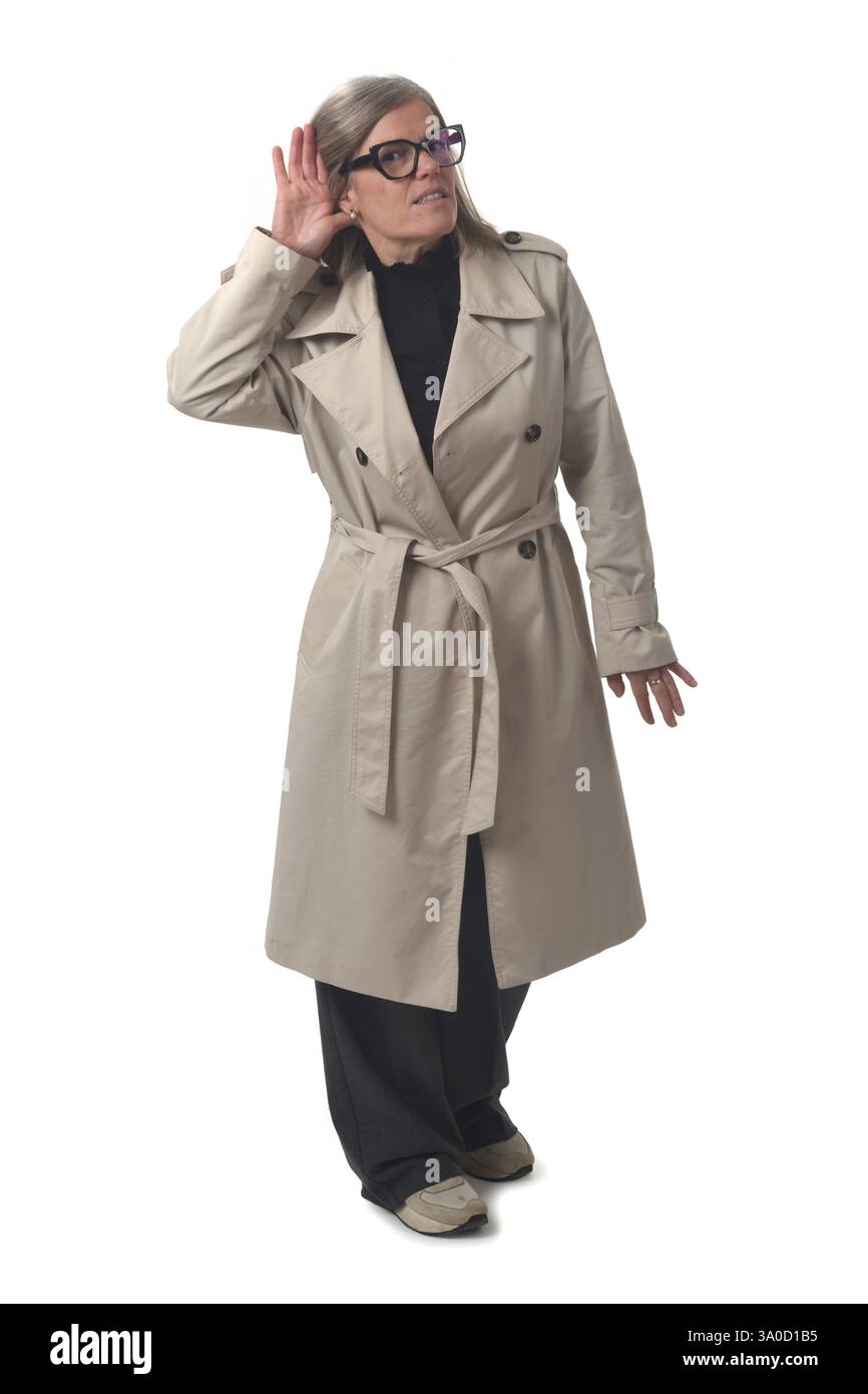 front view of a woman with hand on ear who is listening on white ...