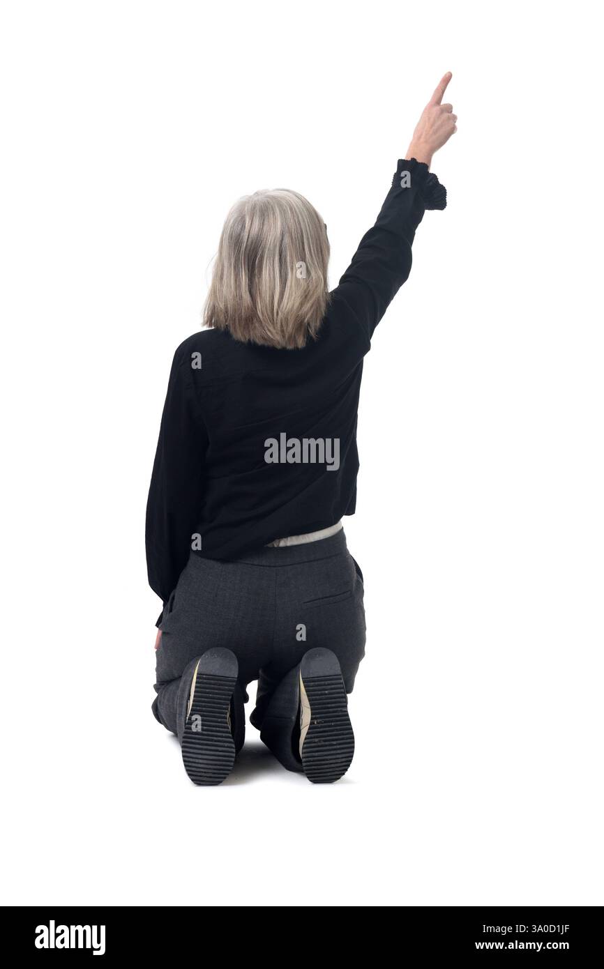 back view of a woman on knees pointing and looking up on white ...