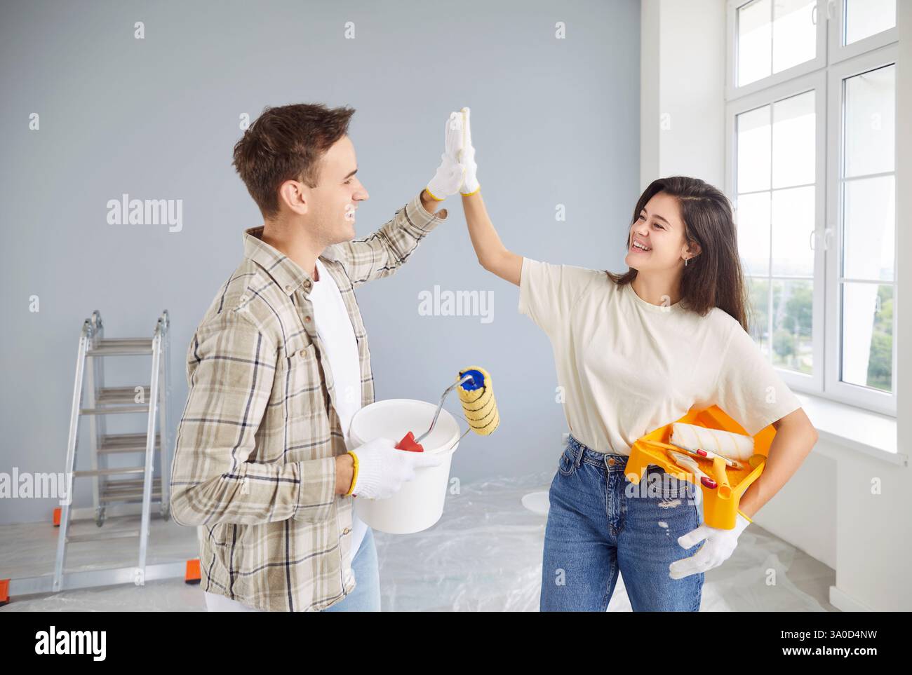 Happy Family Couple Giving High Five During Home Renovation Stock Photo ...
