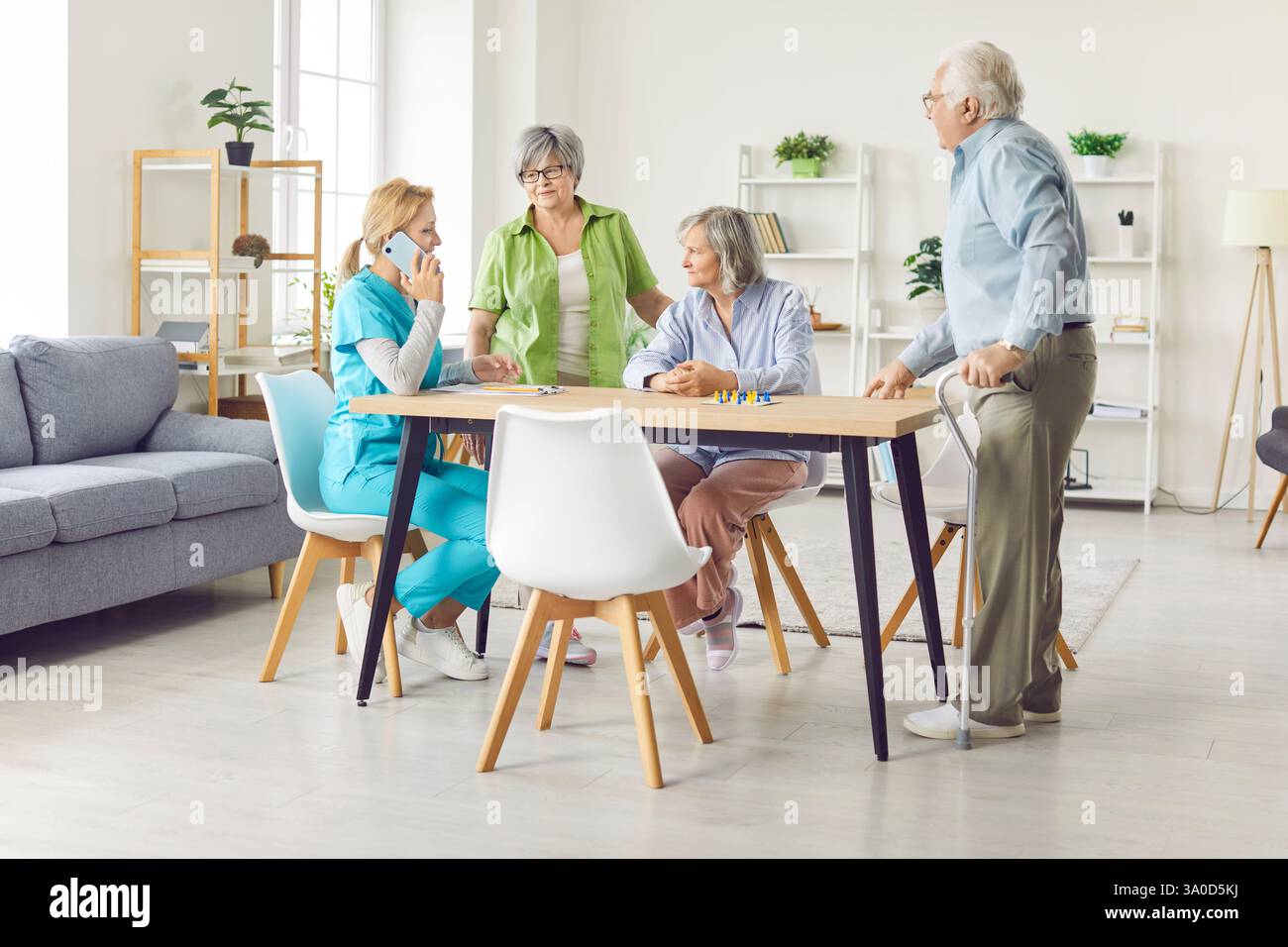 Senior old group and caring kind nurse together making phone call ...