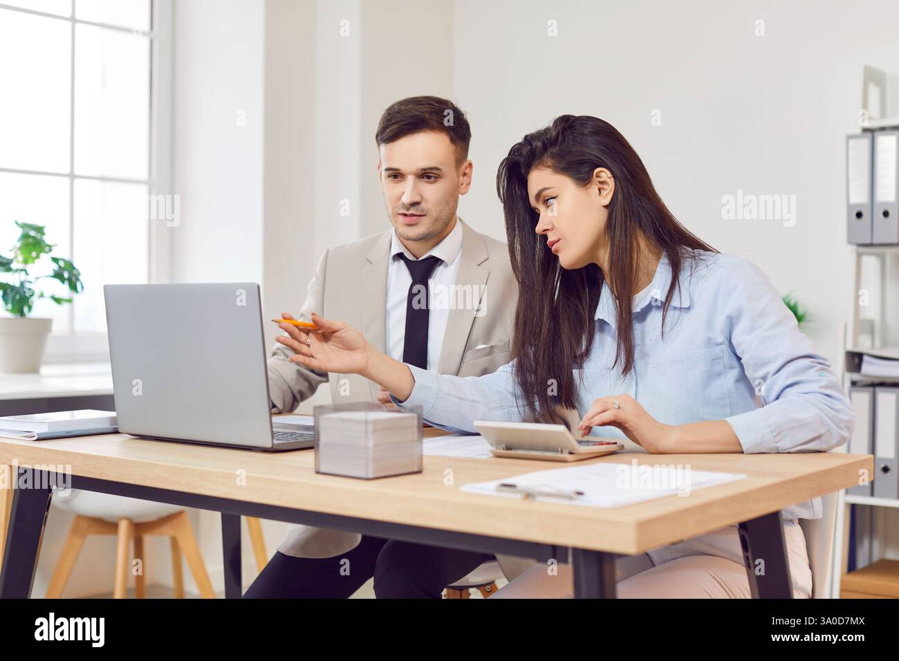 Young positive office male female colleagues working as team at laptop ...