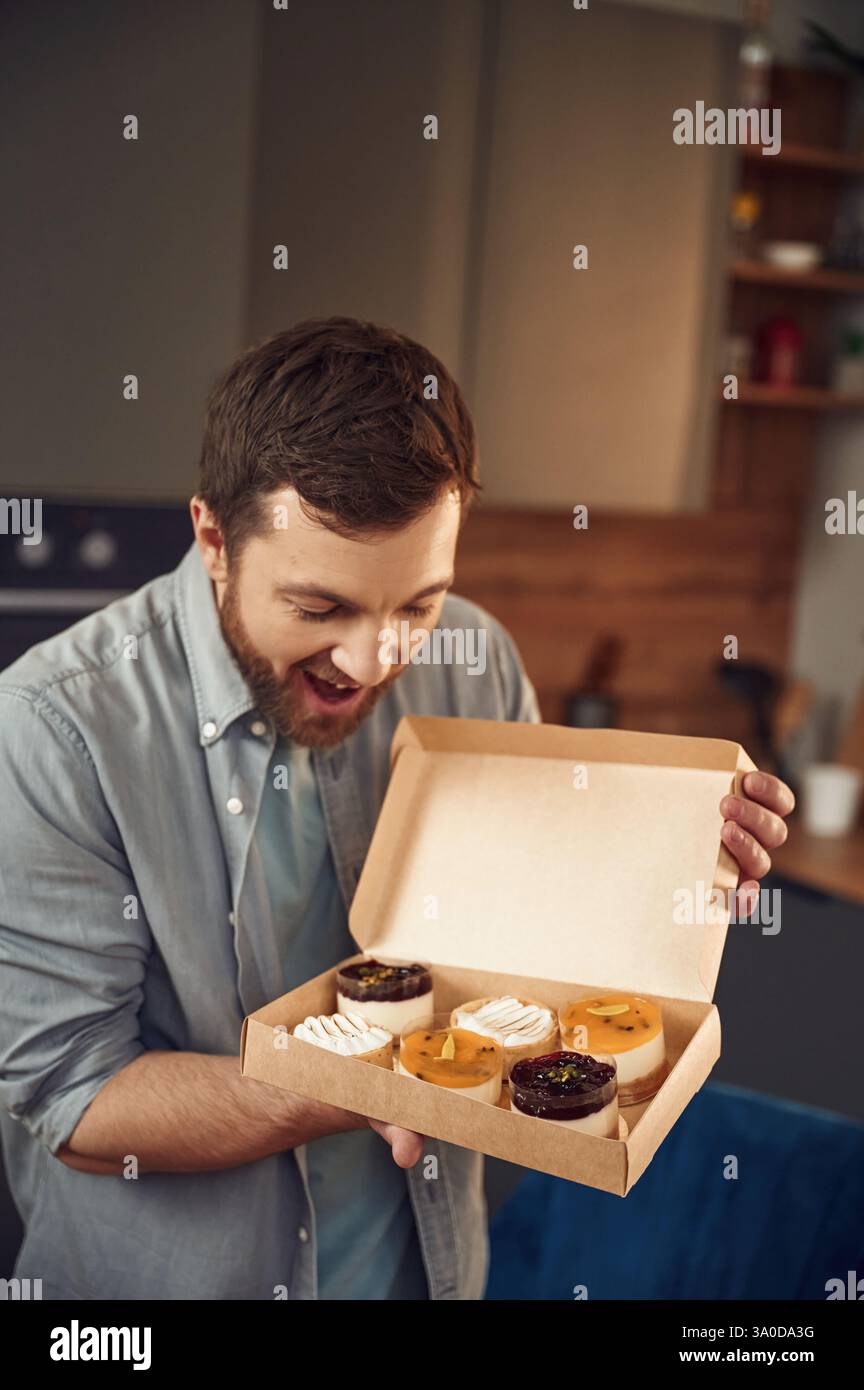 Man is with delicious desserts that are in the eco boxes. Standing ...