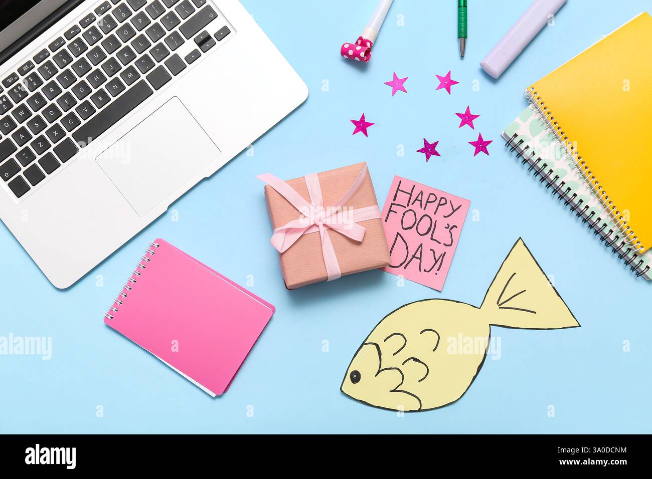 Laptop, gift box, notebooks and sticky notes on blue background. April ...