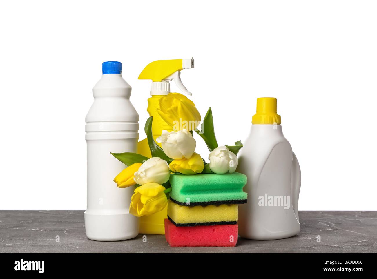 Bottles of detergents with cleaning sponges and tulip flowers on table ...