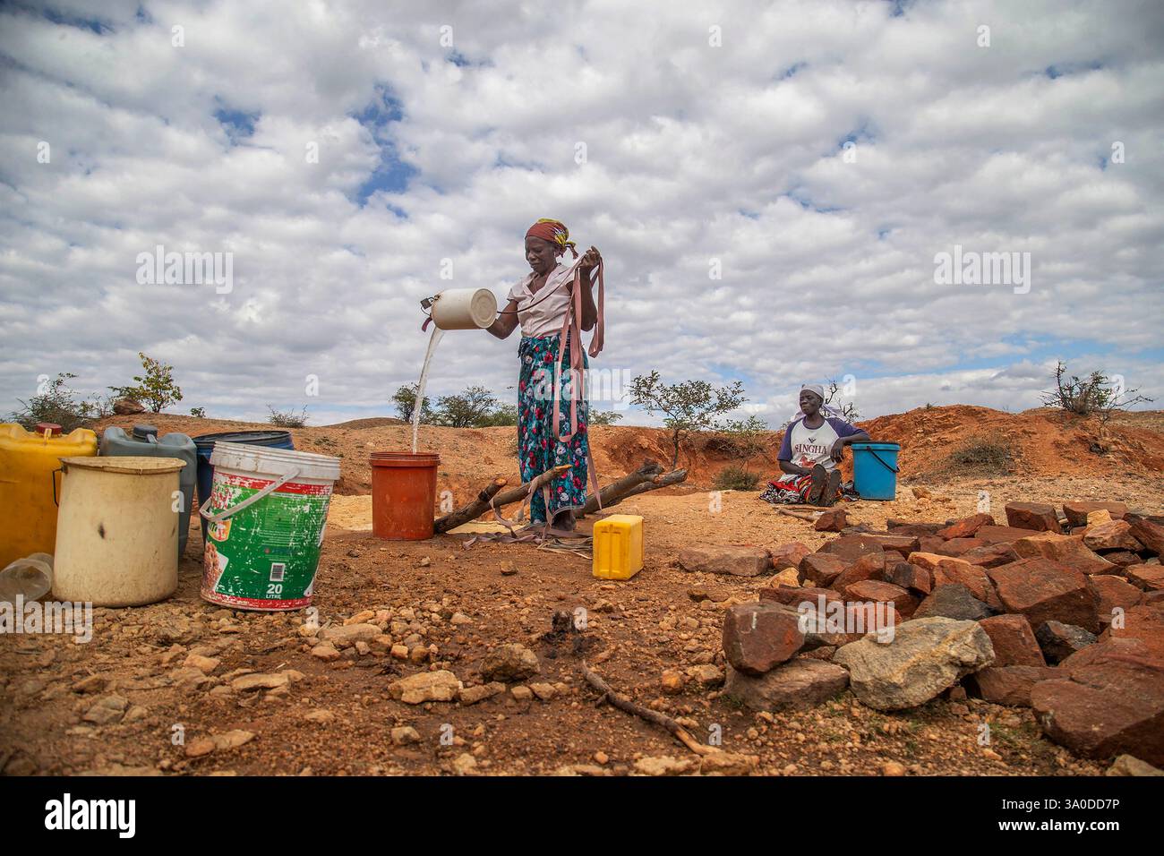 FILE - Villagers fetch water from a makeshift borehole in Mudzi ...