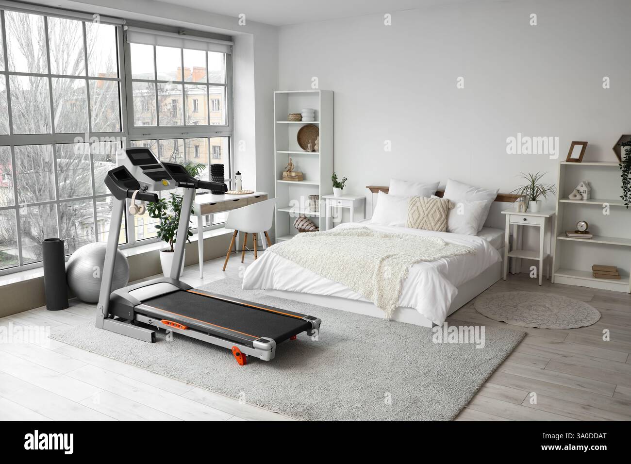 Interior of light bedroom with treadmill, tables and shelf units Stock ...
