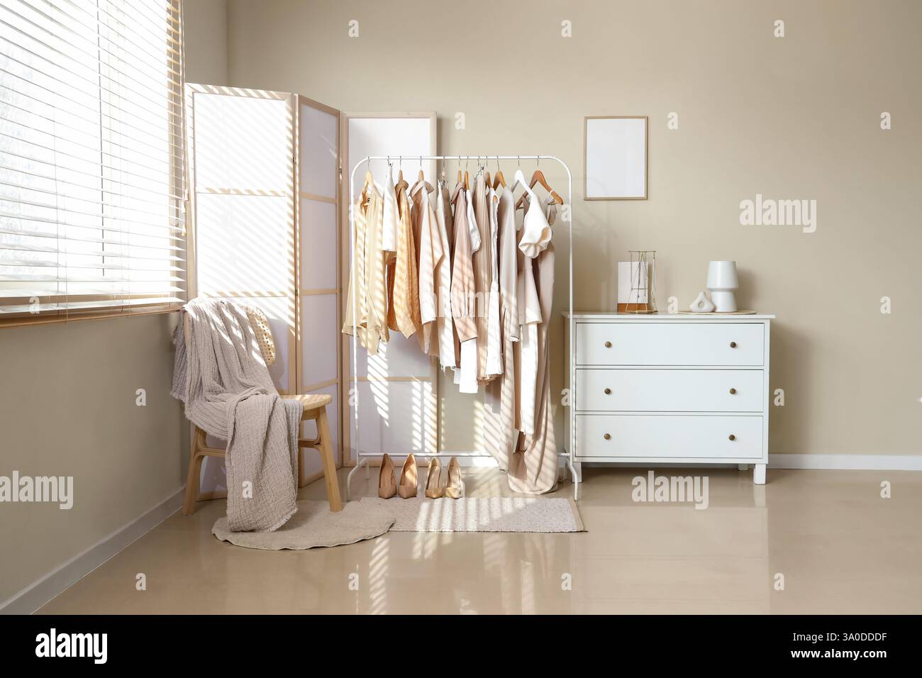 Interior of boutique with clothes rack, chair and folding screen Stock ...