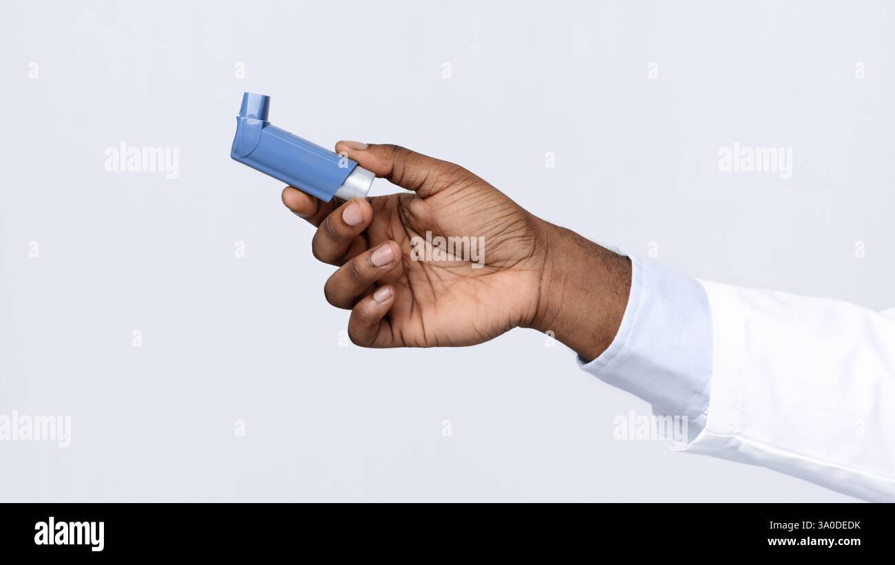 Close up of asthma inhaler holding by african doctor Stock Photo - Alamy