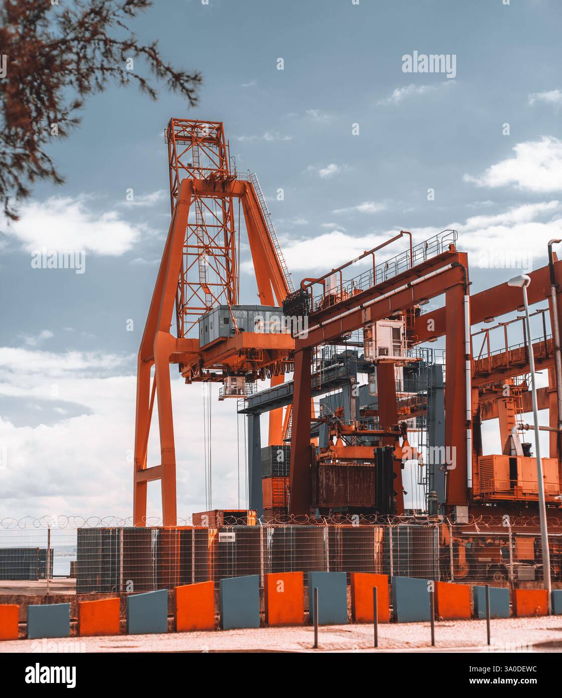 Large industrial port cranes in orange color operating at a shipping ...
