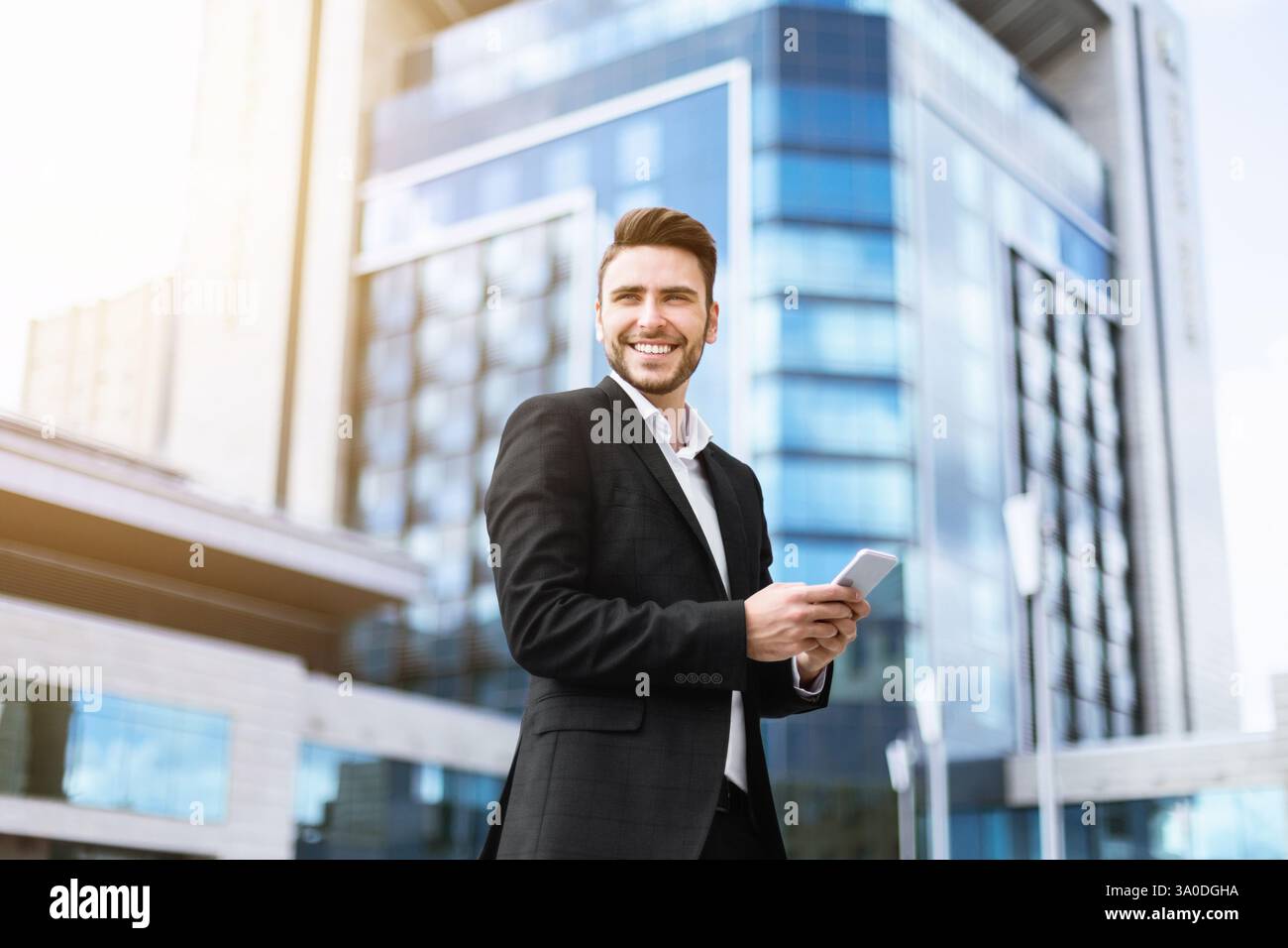 Happy CEO with smartphone in downtown area of modern metropolis Stock ...
