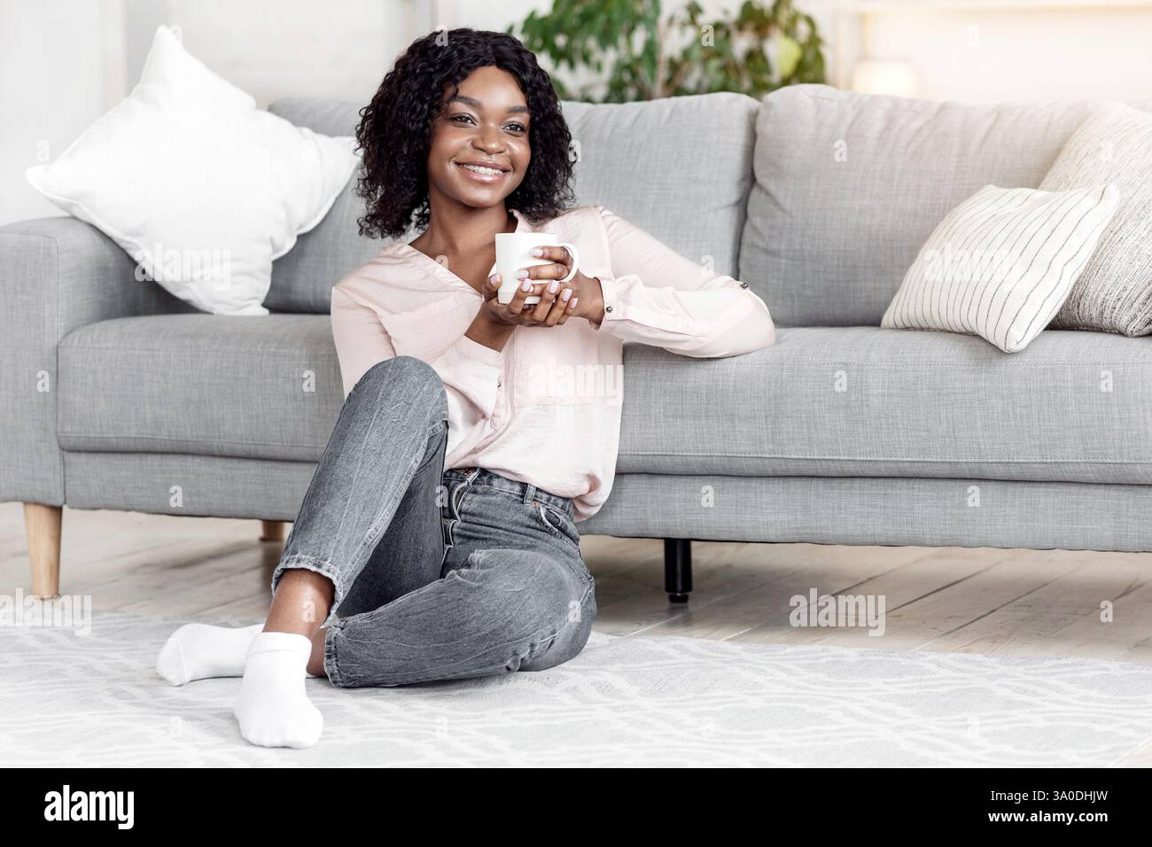 Dreamy African American Woman Unwinding At Home With Cup Of Coffee ...