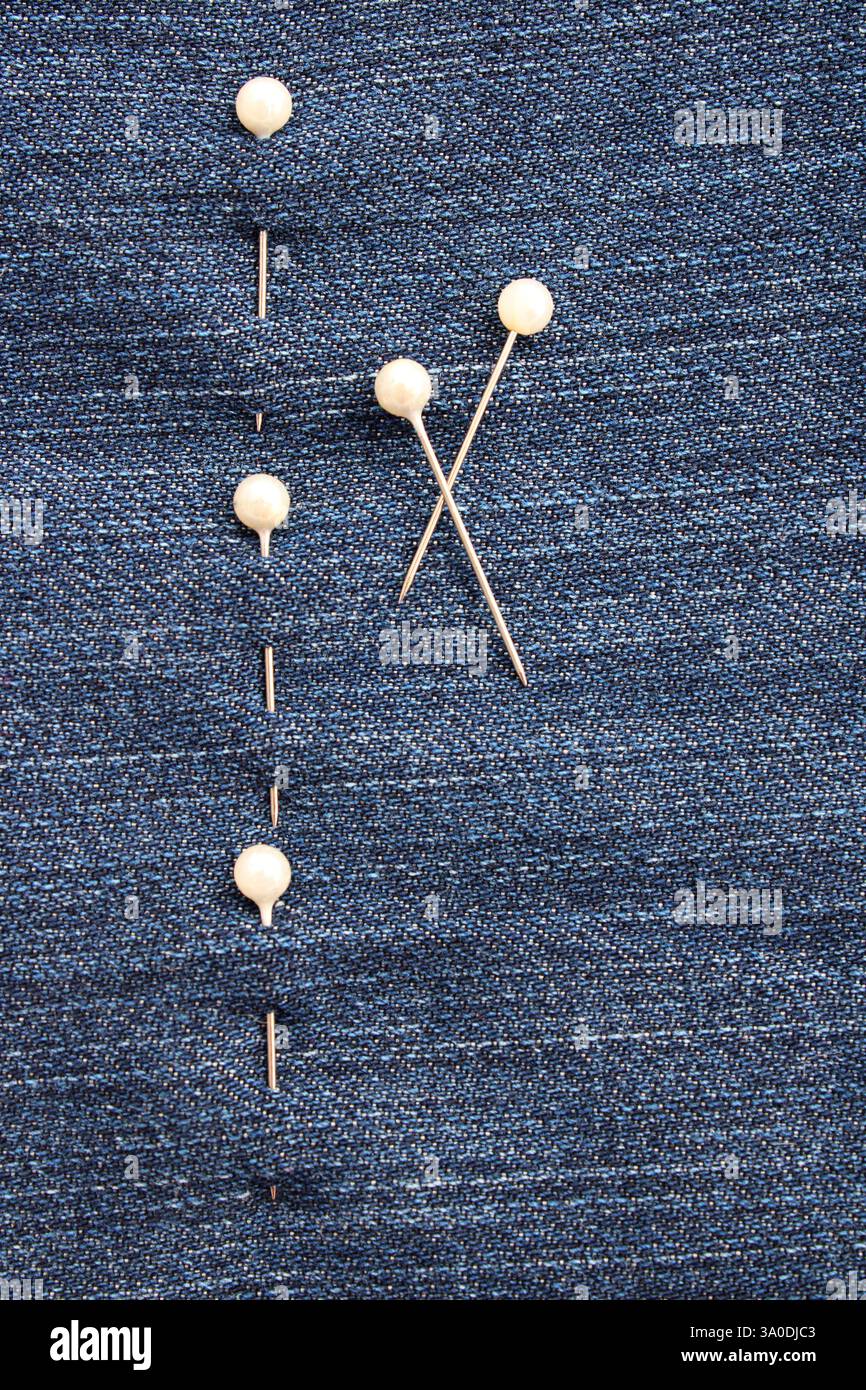 Sewing pins on denim fabric - vertical format Stock Photo - Alamy