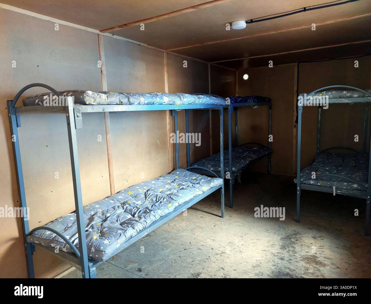 Inside a cozy accommodation, several bunk beds line the walls, offering ...