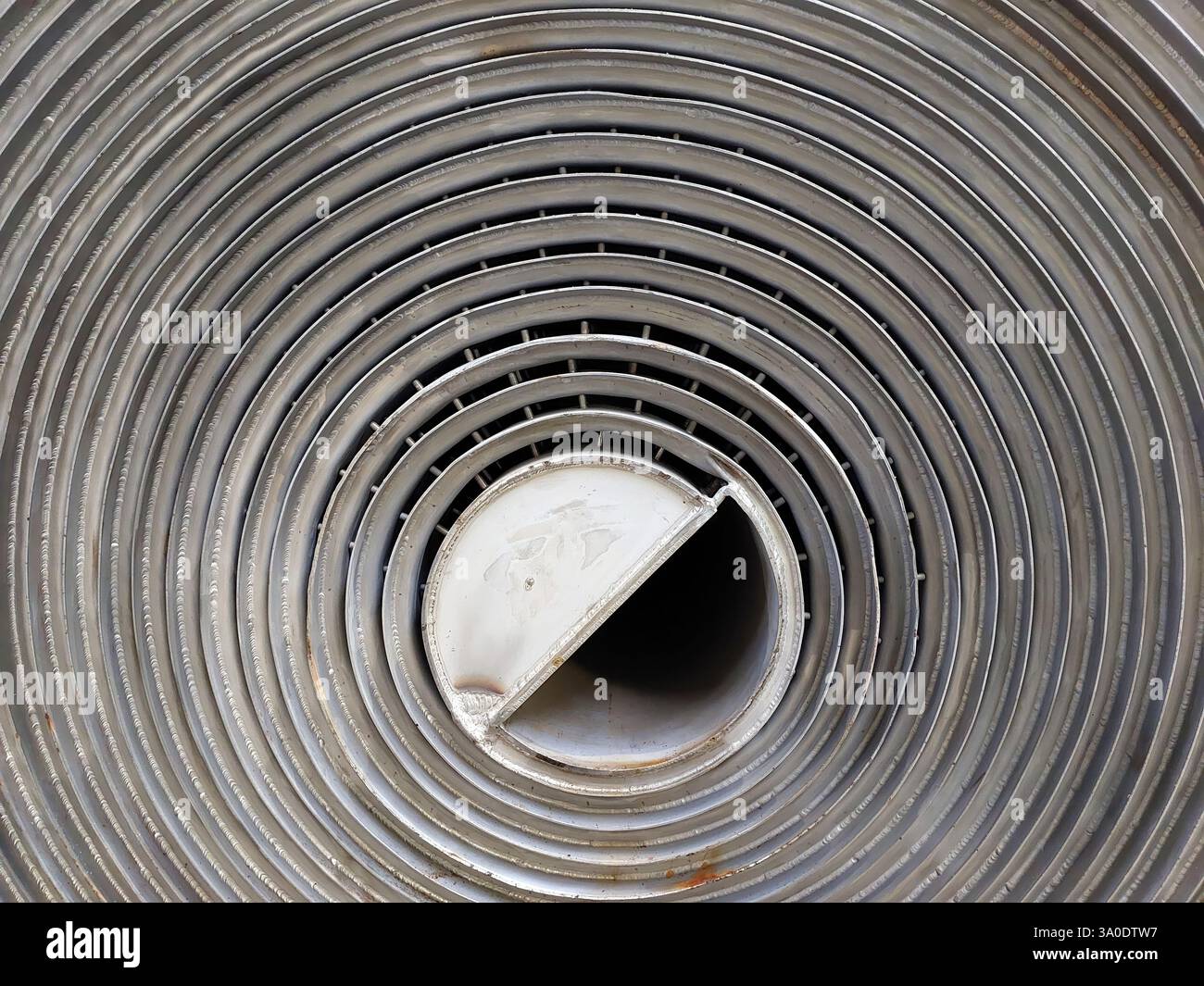 Spiral heat exchanger made of stainless steel is displayed from above ...